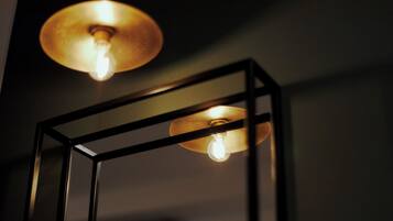 Um interior moderno com estrutura metálica emoldurando formas geométricas e duas luminárias pendentes.