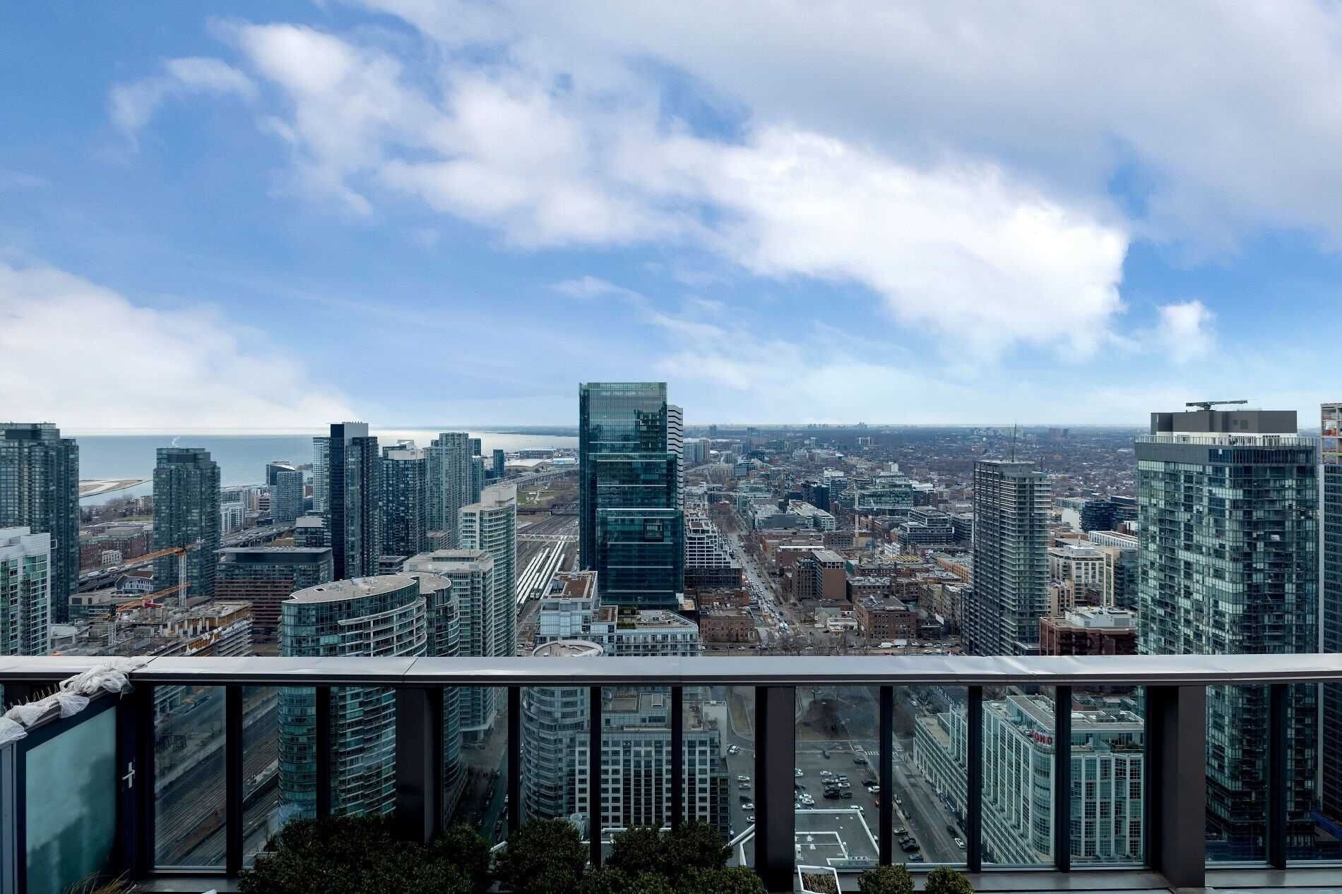 Um edifício alto com vista para o horizonte urbano, incluindo diversos edifícios e um corpo d'água ao longe.
