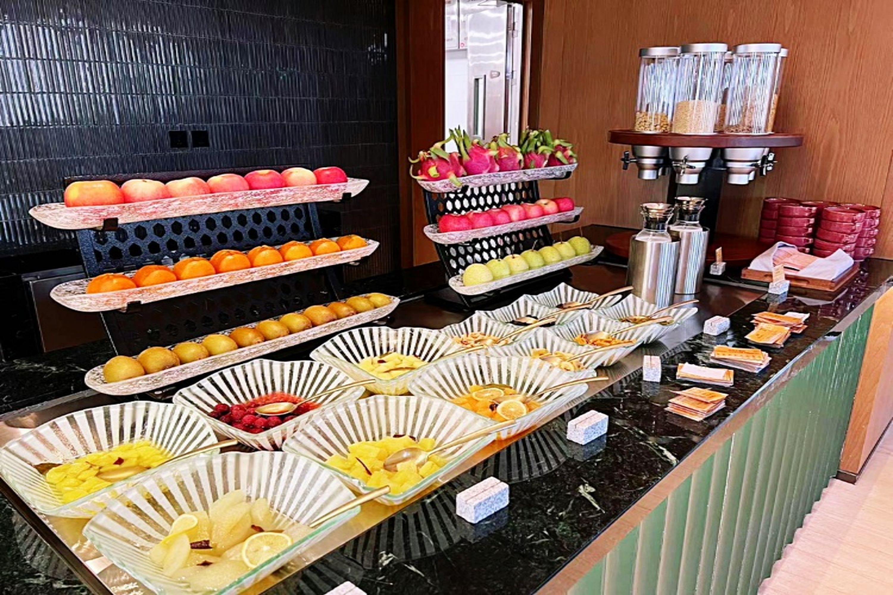 Buffet com diversas frutas e bebidas.