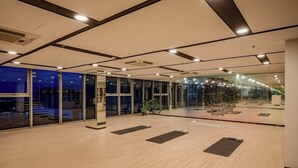 Quarto espaçoso com grandes janelas, piso de madeira e parede com espelho.