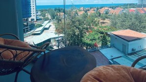 Uma varanda com vista para a paisagem urbana, incluindo edifícios e árvores.