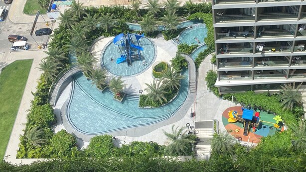 Vista aérea de uma área residencial com piscina, espaço de recreação infantil e um edifício de vários andares.