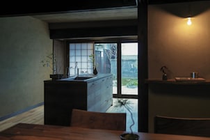 Cozinha moderna com ilha de madeira, pia e área de refeições com mesa e cadeiras.