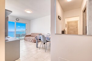 Uma sala de estar moderna com varanda, área de jantar e cozinha.