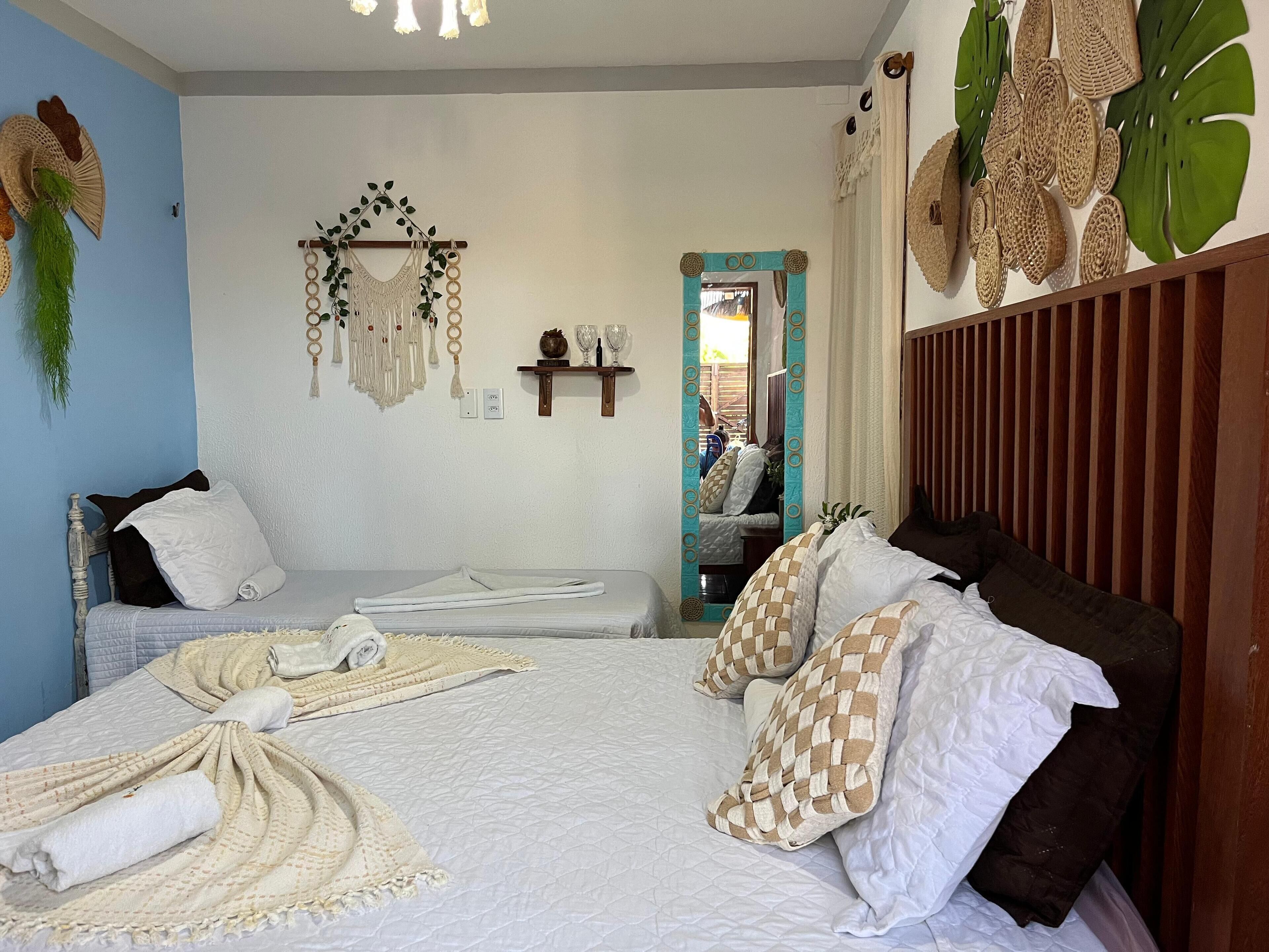 Quarto de hotel com duas camas, um espelho e decorações nas paredes.