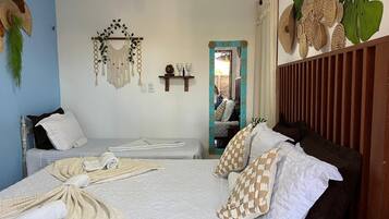 Quarto de hotel com duas camas, um espelho e decorações nas paredes.
