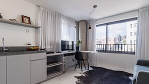 Cozinha moderna com área de jantar, uma grande janela com vista para a cidade e um tapete preto e branco exclusivo.