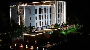 Um hotel de vários andares com design moderno, com varandas e um terraço no telhado.