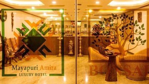 Interior do Hotel Mayapuri Amira Luxury, com área de recepção, assentos e elementos decorativos.