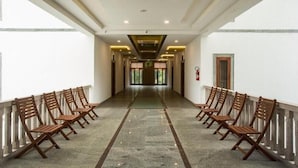 Um corredor com fileiras de cadeiras de madeira em ambos os lados, levando a uma porta no final.
