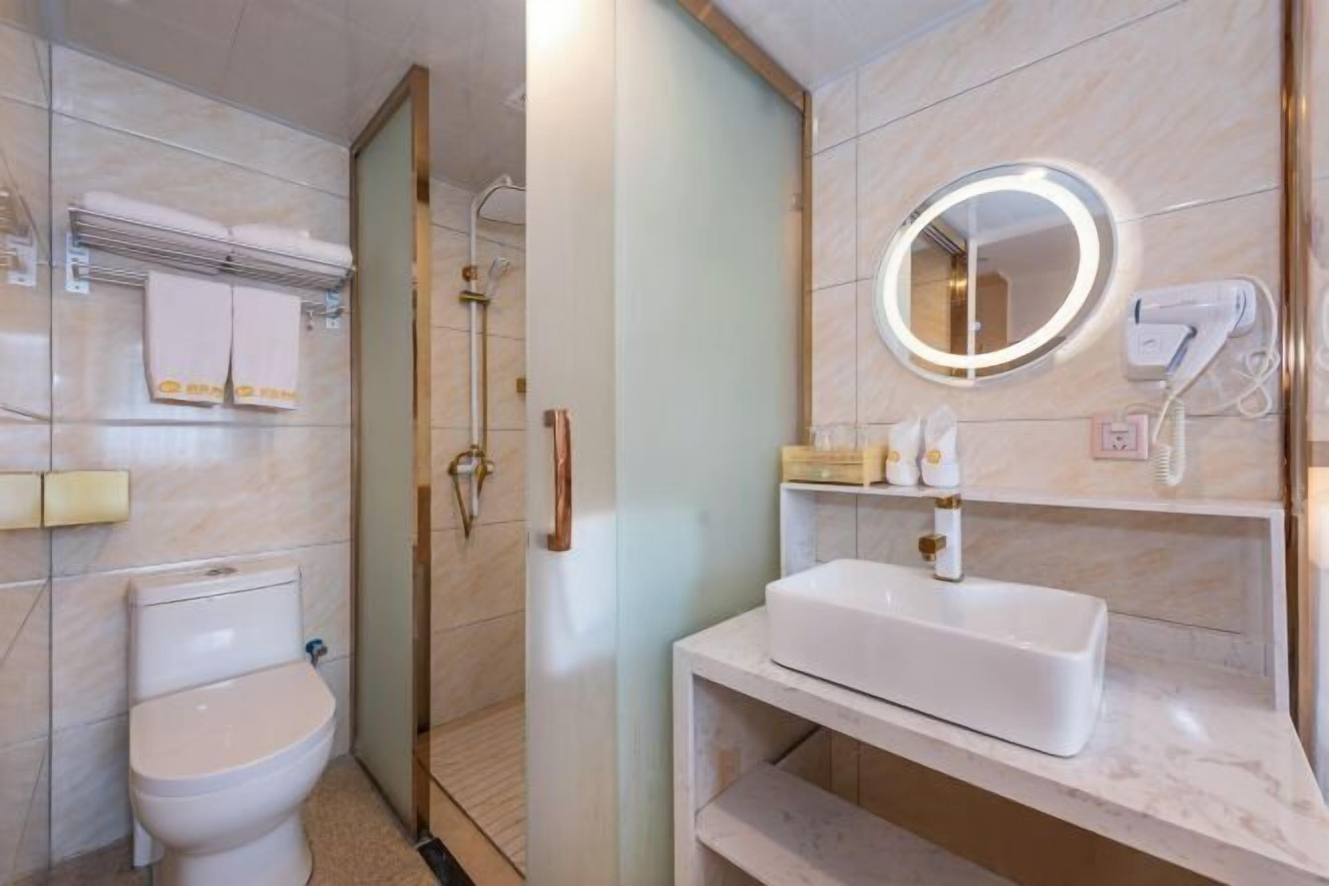 Uma casa de banho moderna com sanita, chuveiro e lavatório.