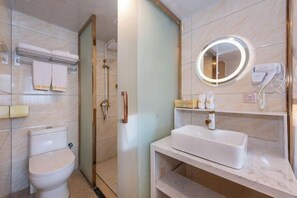 Uma casa de banho moderna com sanita, chuveiro e lavatório.