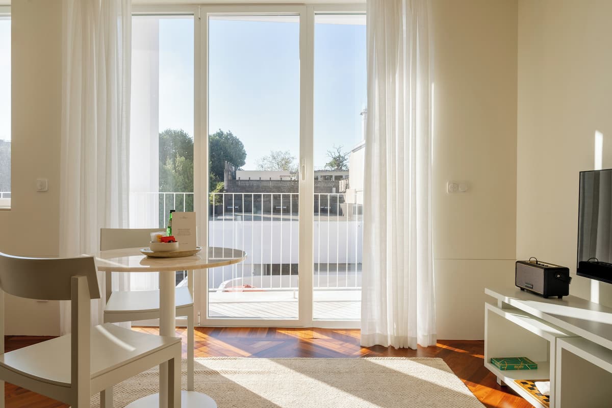 Apartamento superior, sacada, vista para a piscina | Área de estar | TV de tela plana 43 polegadas com canais a cabo