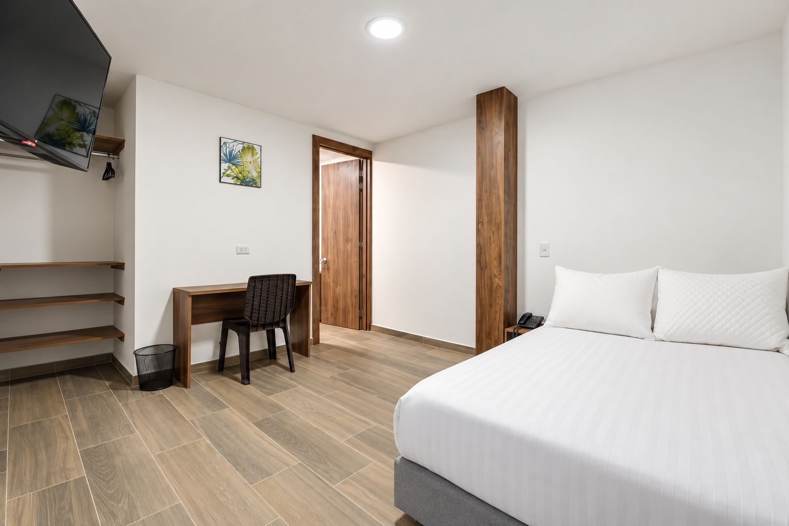 Quarto com cama, escrivaninha e cadeira.