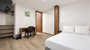 Quarto com cama, escrivaninha e cadeira.