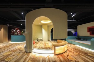 Uma área de recepção com uma mesa em arco, um espaço para sentar e um piso estampado.