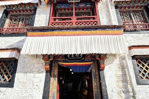 Um edifício tradicional com uma entrada imponente, decorações elaboradas e um telhado em telhas.