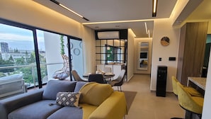 Uma sala de estar moderna com sofá, área de refeições e cozinha.