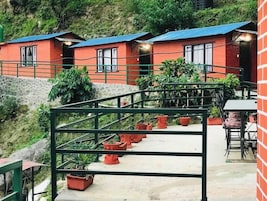 Um hotel numa encosta com edifícios de tijolo vermelho, área de estar ao ar livre e escadaria que dá para a entrada.