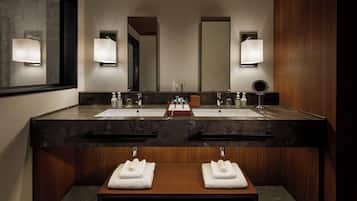 Um polibã e uma banheira separados, um secador de cabelo, roupões