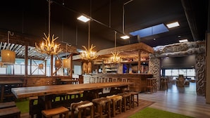 Um bar rústico com mobiliário de madeira e um fundo de parede de pedra.