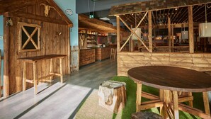 Um interior rústico com estruturas de madeira, um bar e uma mesa grande.