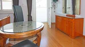 Um quarto com uma mesa de vidro redonda, um armário de madeira e um espelho grande na parede.