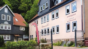 Um edifício europeu tradicional com várias janelas e uma escadaria de pedra que leva à entrada.