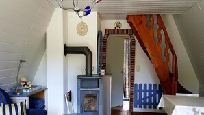 Uma sala de estar aconchegante com um sofá, uma mesinha, uma lareira e uma escada.