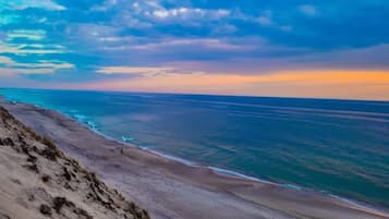 Uma praia com céu claro e oceano.