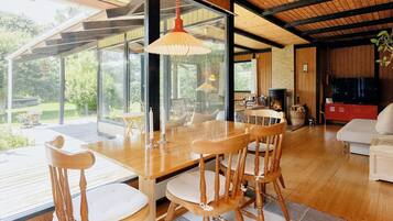 Uma sala de estar moderna com uma mesa de jantar de madeira, cadeiras e lareira.