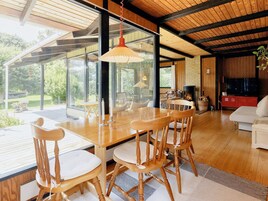 Uma sala de estar moderna com uma mesa de jantar de madeira, cadeiras e lareira.