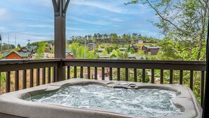 Uma banheira de hidromassagem em uma varanda com vista para uma área residencial.