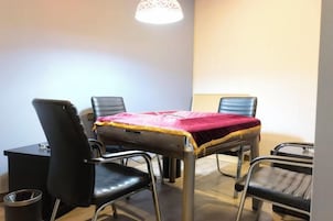 Uma sala de conferências com uma mesa, quatro cadeiras e um abajur.