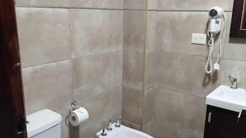 Casa de banho compacta com sanita, bidé e cabine de duche.