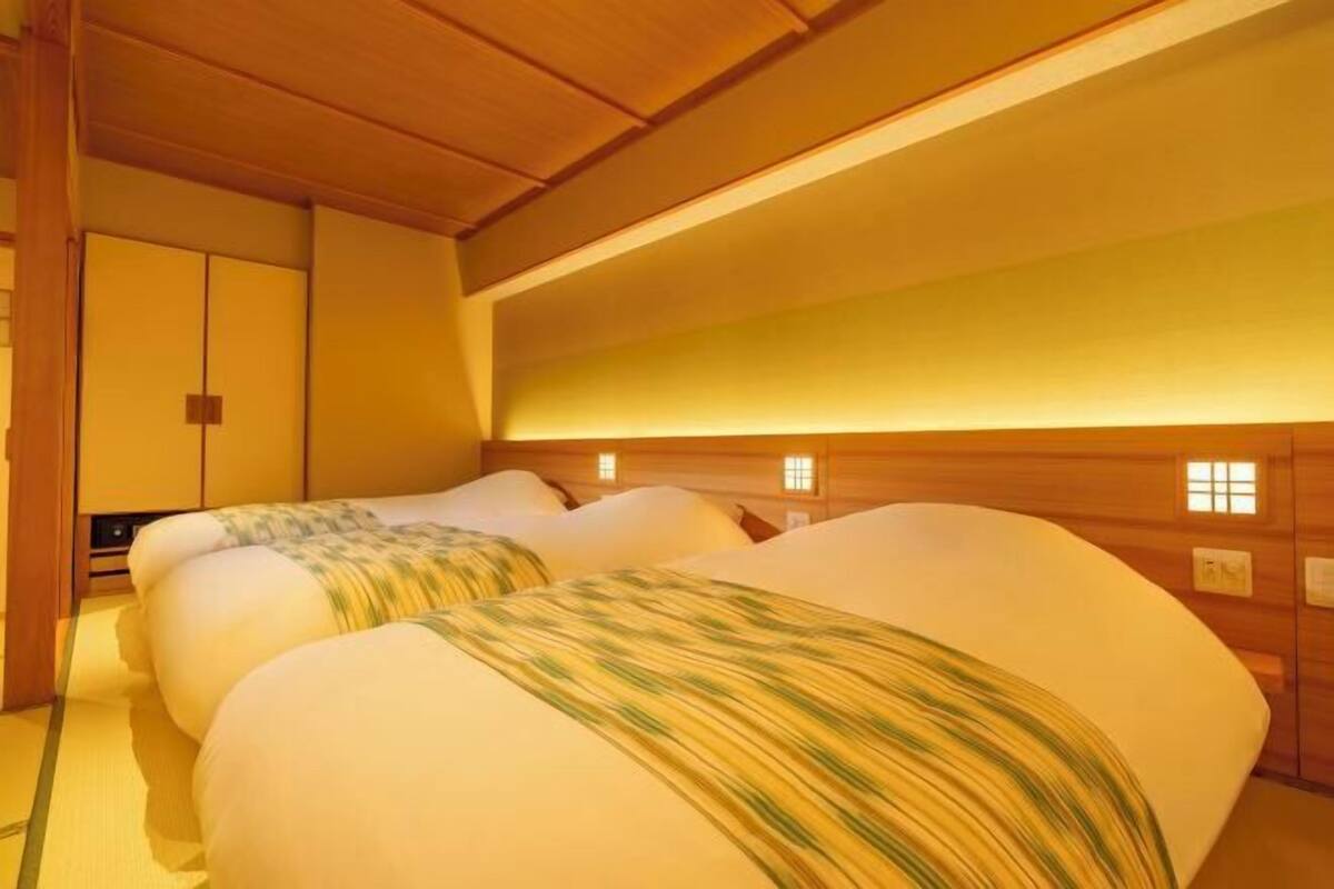 Um quarto em estilo japonês tradicional, com tatames, teto baixo e painéis de madeira.