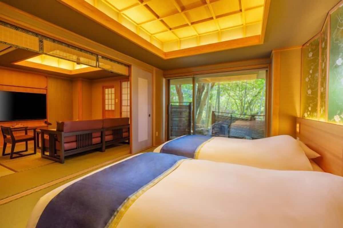 Quarto de hotel com uma cama grande, uma escrivaninha e vista para o exterior.