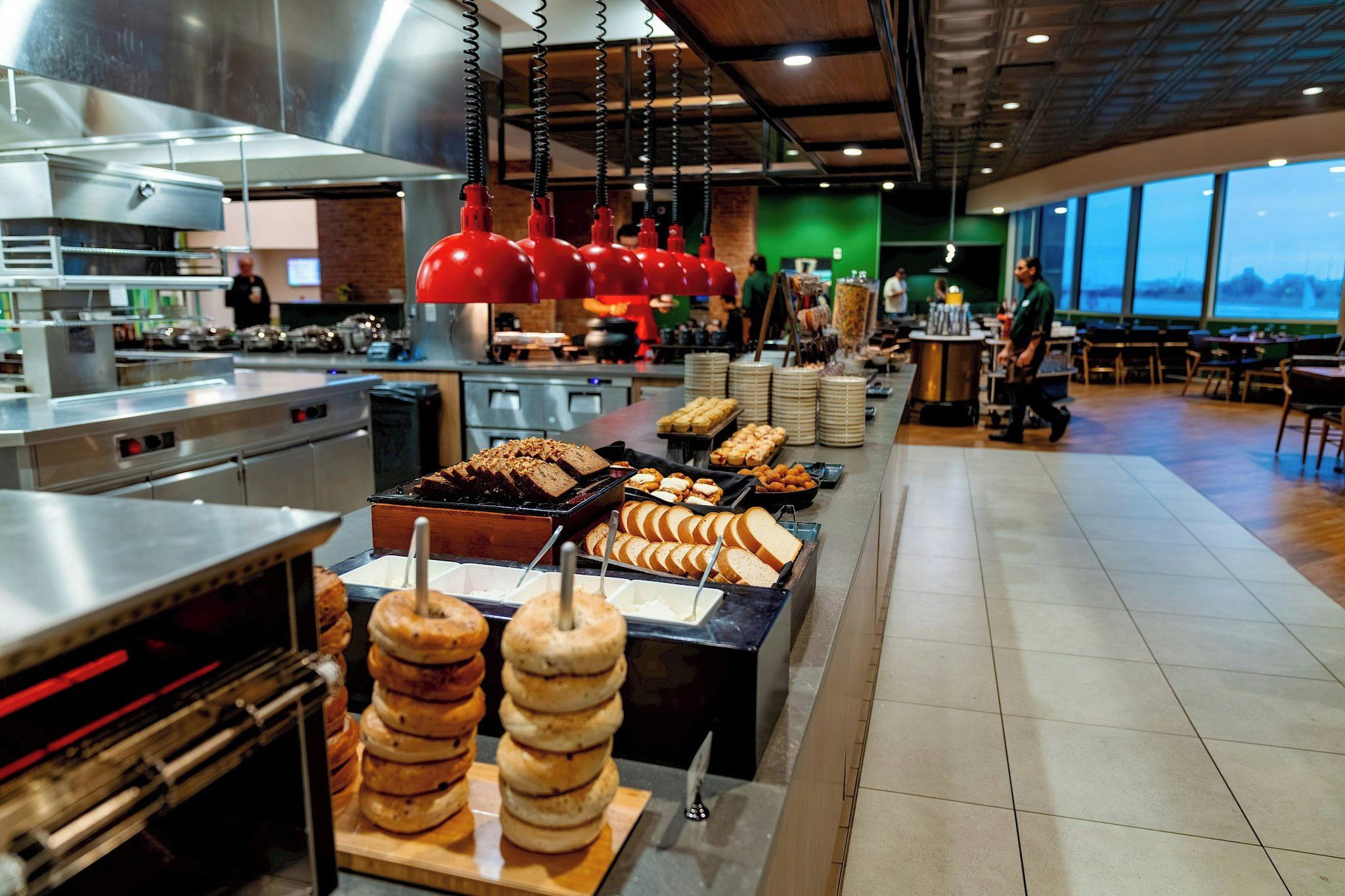 Buffet com diversos alimentos e cozinha ao fundo.