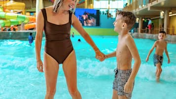 Piscina interna com água cristalina, teto alto e elementos estruturais aparentes como vigas e tubulações.