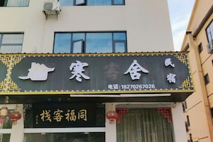 Um edifício com uma placa mostrando caracteres chineses e um número de contato.