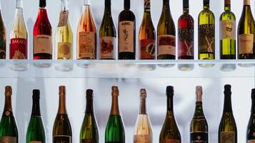 Uma estante com diversos vinhos.