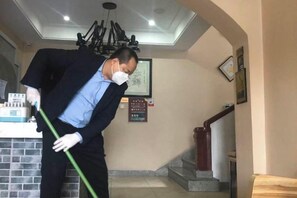 Uma pessoa limpando um saguão com um esfregão.