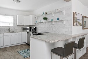 Apartamento luxo, vista parcial para o oceano | Cozinha privada | Micro-ondas, fogão, cooktop, talheres/pratos/utensílios de cozinha