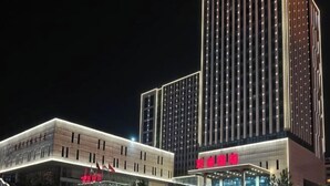 Um hotel moderno com uma torre vertical imponente e um edifício mais baixo com fachada plana.