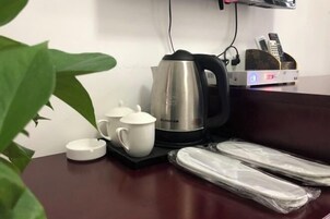 Uma mesa com chaleira, chávenas e suporte para comando.