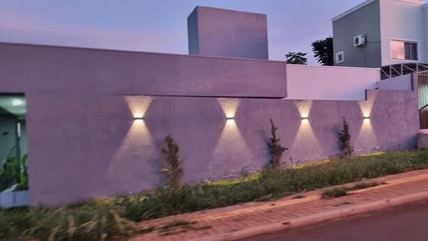 Um edifício moderno com fachada plana e iluminação embutida.
