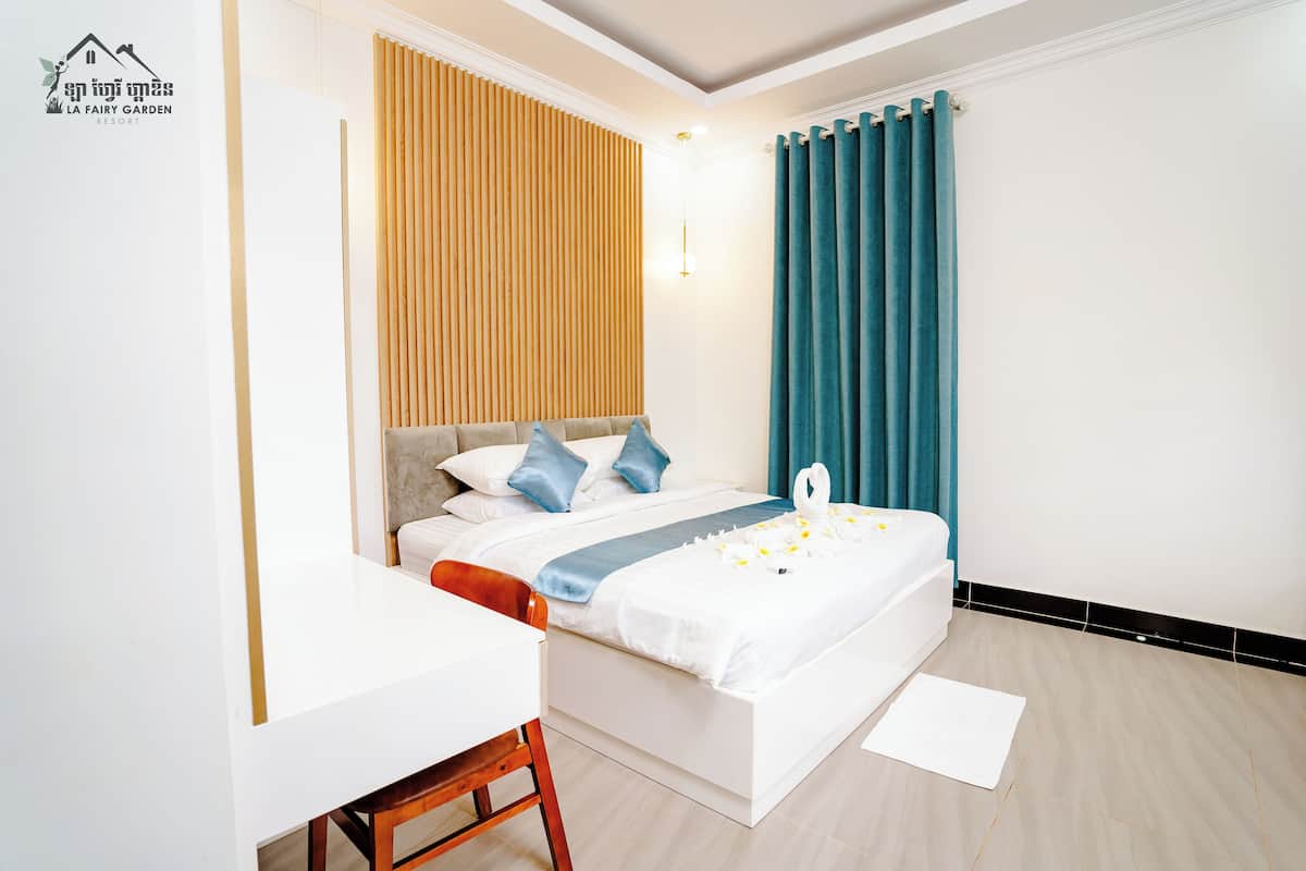 Quarto de hotel moderno com cama, escrivaninha e cadeira.