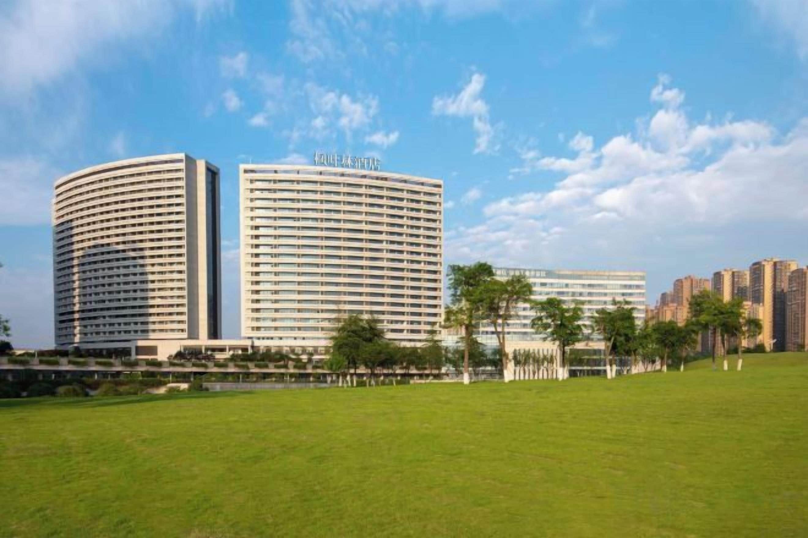 Um hotel com fachada curva, vários andares e telhado plano.