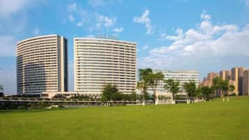 Um hotel com fachada curva, vários andares e telhado plano.