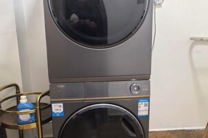 Máquina de lavar e secar empilhadas, com uma estante de metal e uma garrafa de detergente.